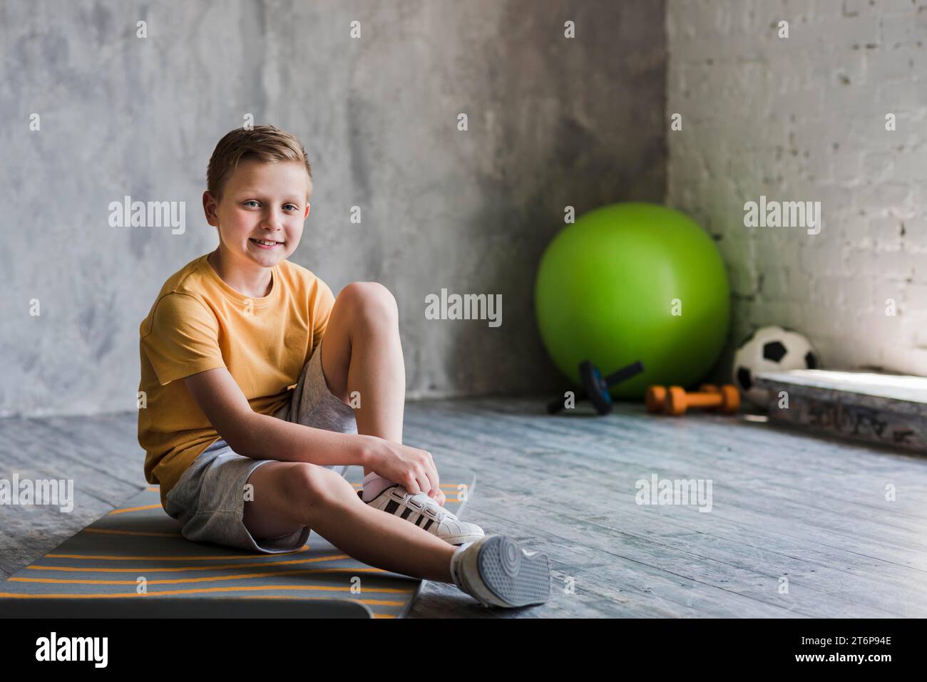 Portrait smiling boy sitting exercise mat looking camera Stock Photo ...