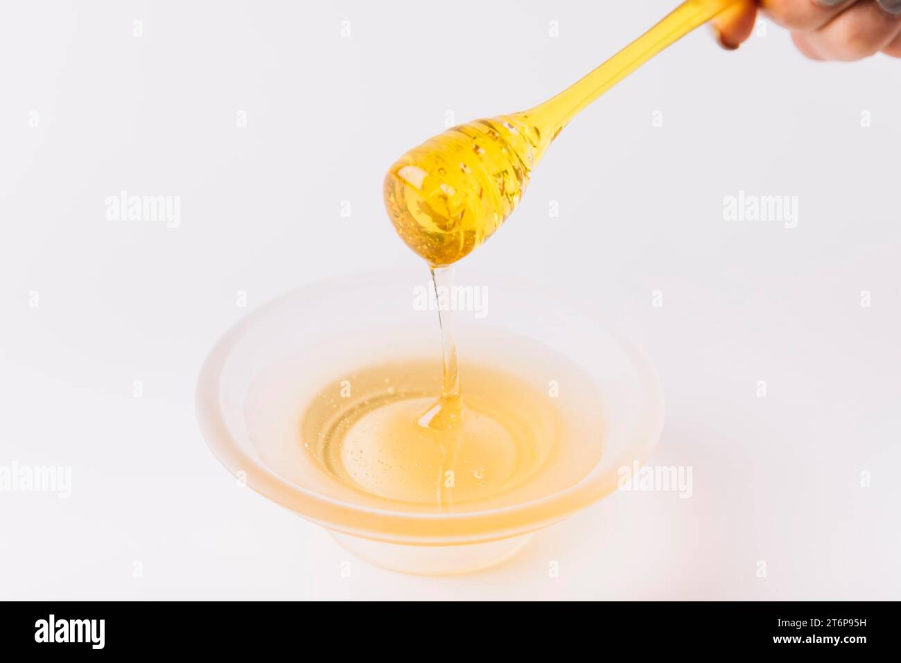 Peron s hand holding dipper bowl honey Stock Photo - Alamy