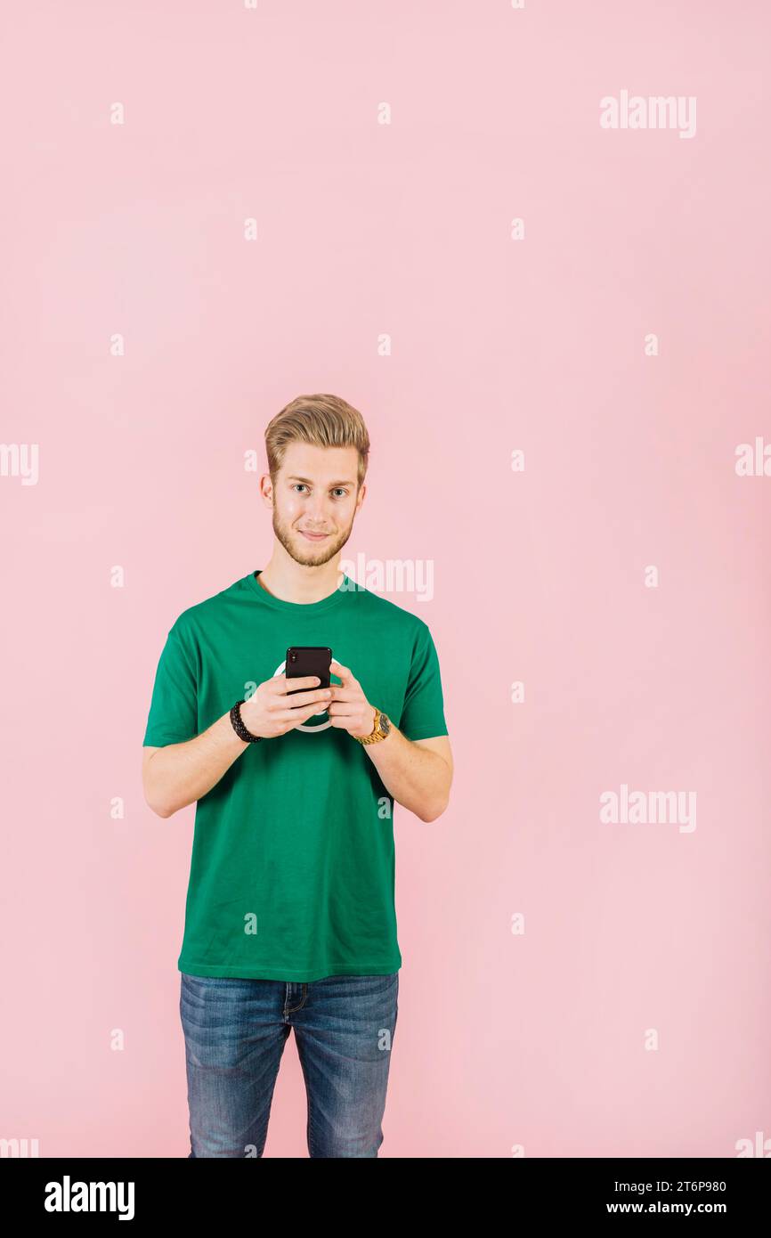 Portrait young man with mobile phone looking camera Stock Photo - Alamy