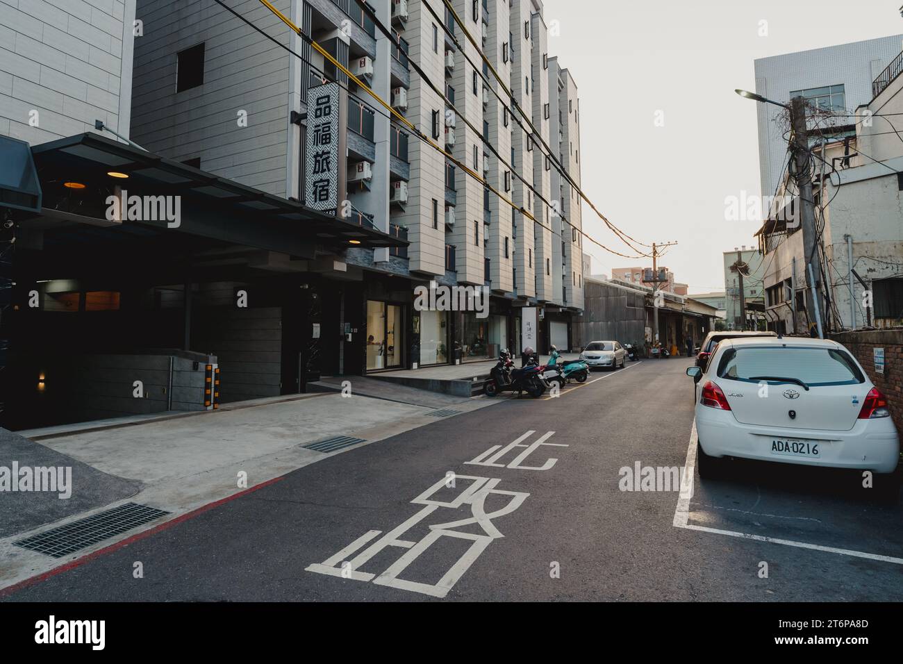 An empty road in Taiwan with cars parked alongside the buildings Stock ...