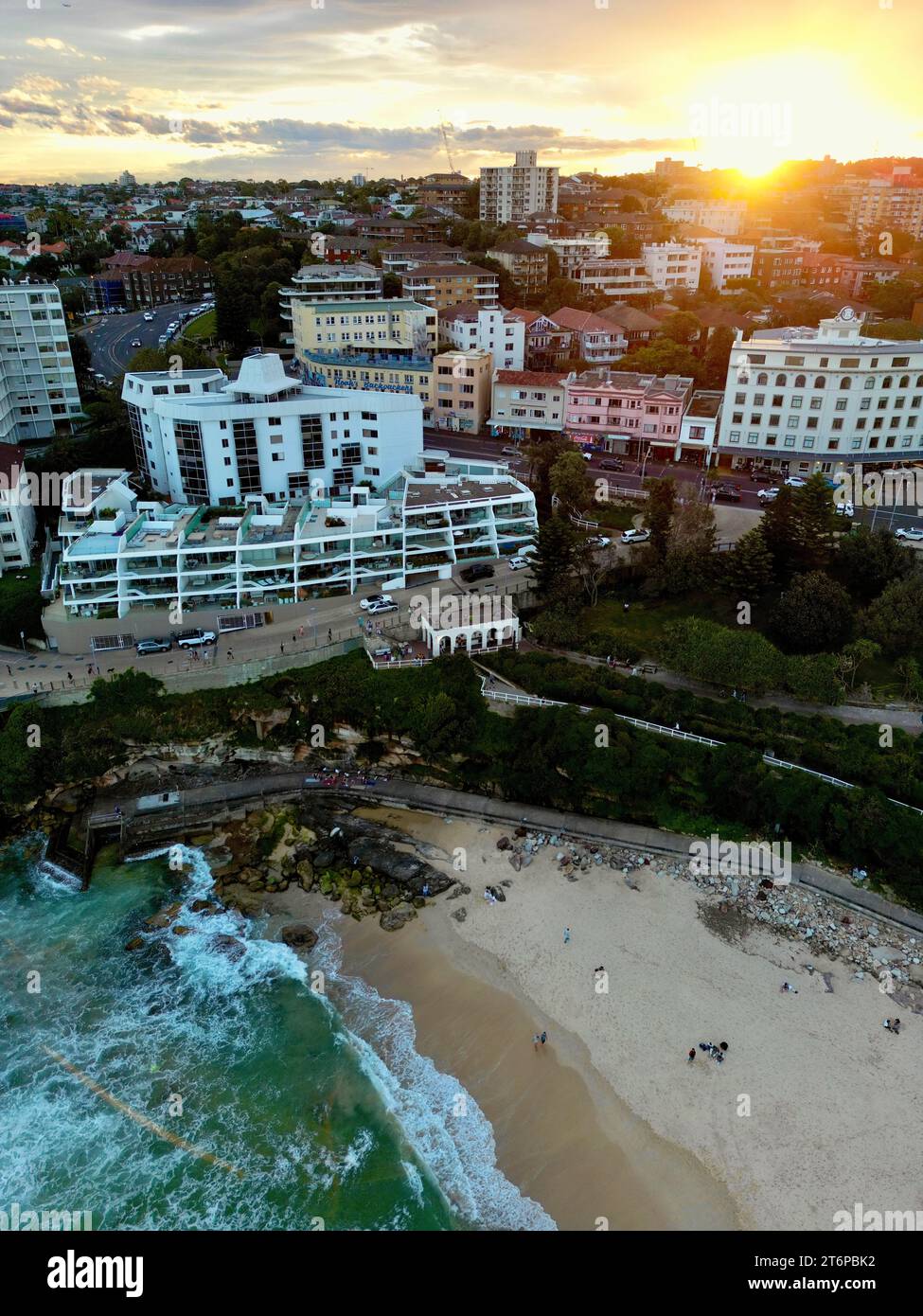 A scenic beach with colorful buildings in the distance illuminated by a ...