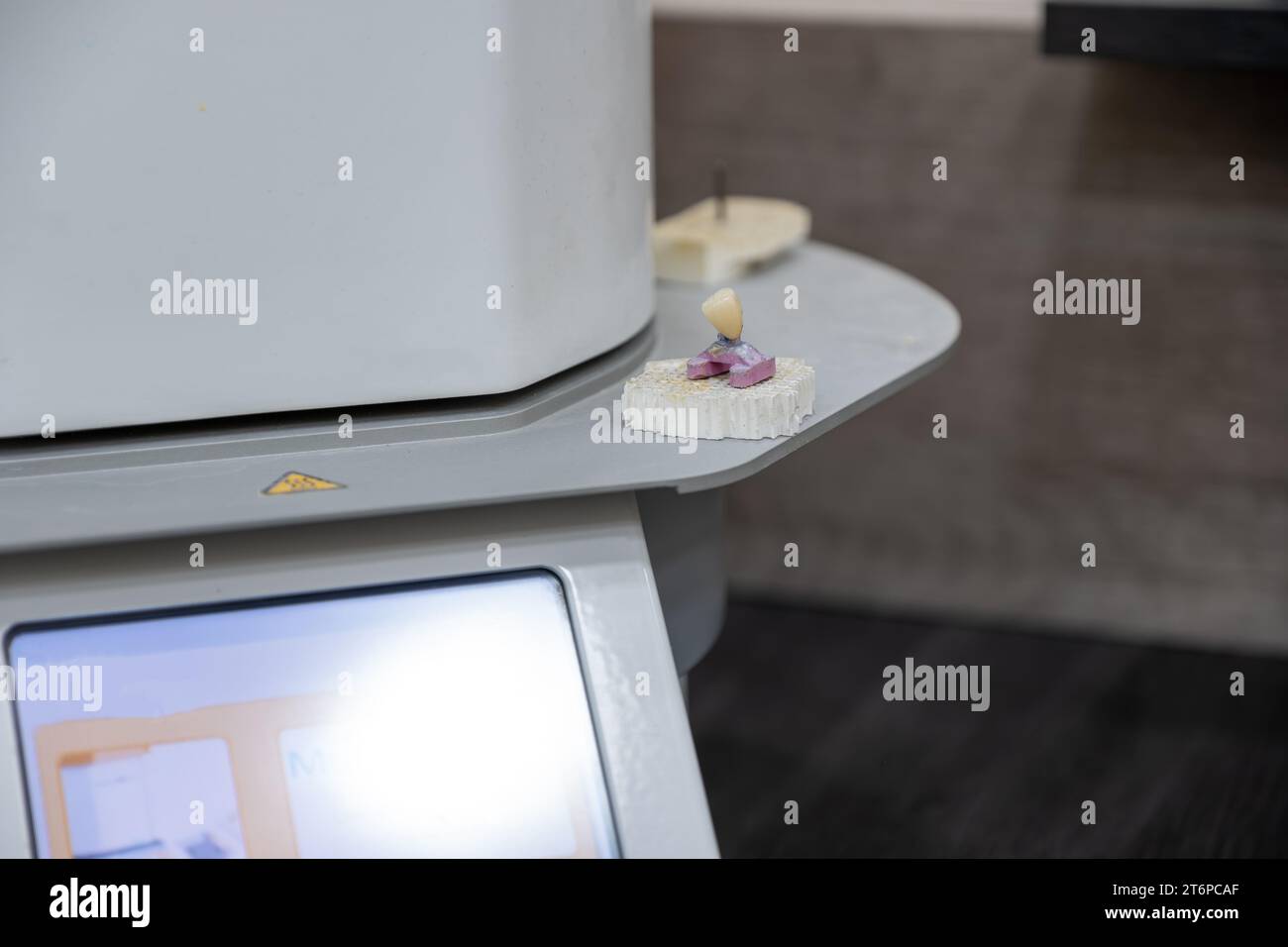 Technician operates high temperature furnace to bake prosthetic ceramic ...