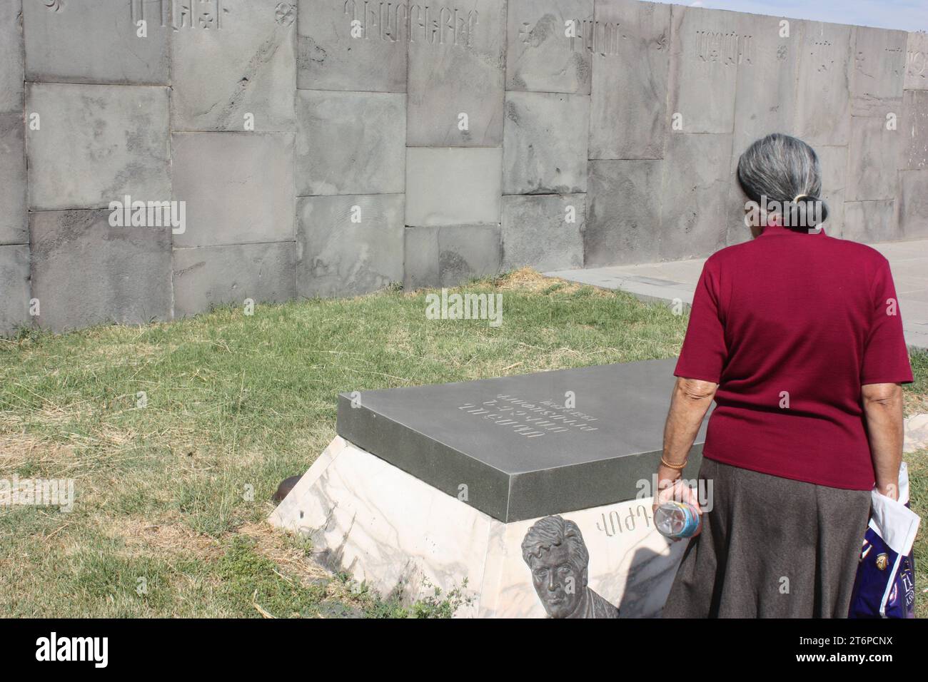 Woman looking at a grave on the Memory Alley at the Tsitsernakaberd ...