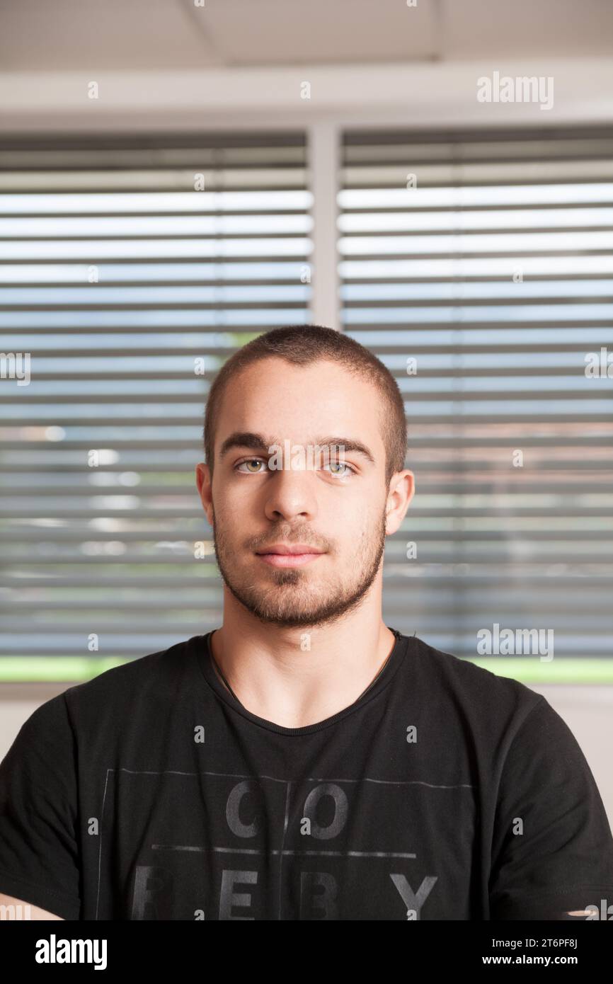 Serene expression defines the young adult against a soft-lit background ...