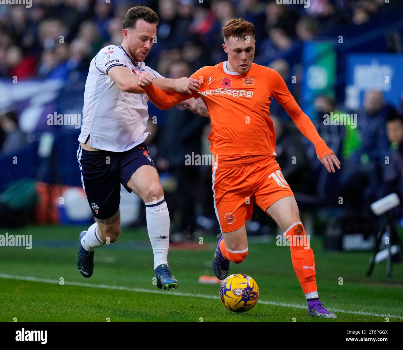 Callum Connolly #2 of Blackpool competes for the ball with Sonny Carey ...