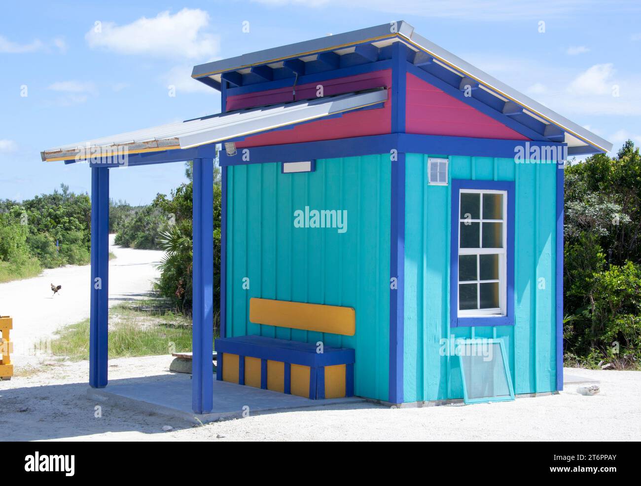 The view of a colorful wooden structure and a rooster running across ...