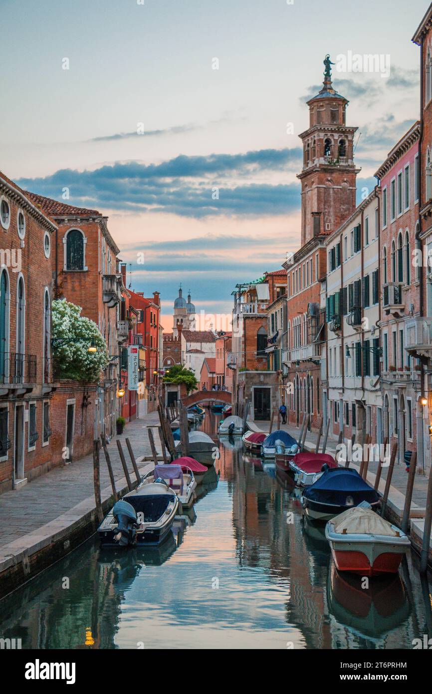 An idyllic riverway with several boats floating peacefully past a ...