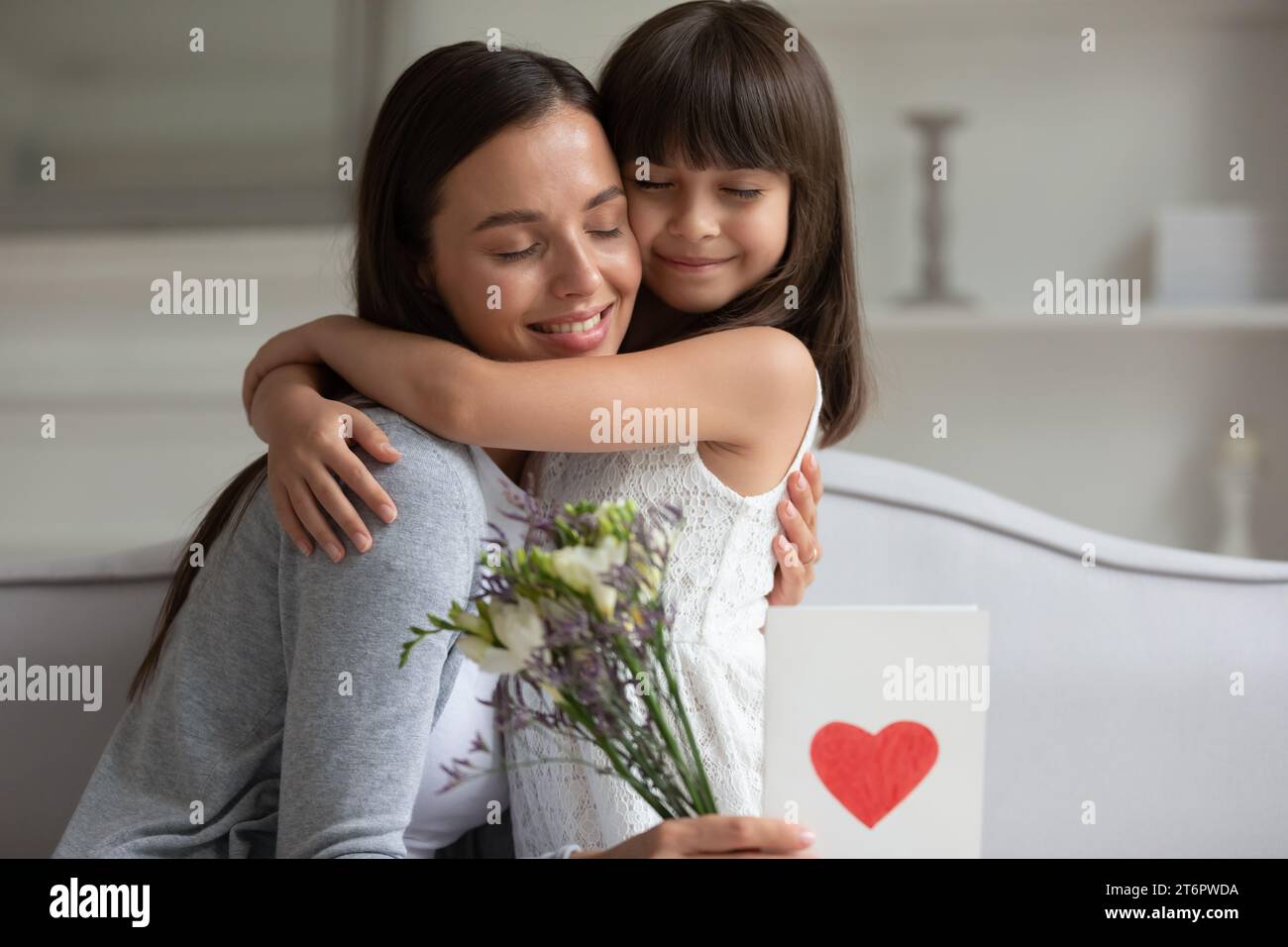 Smiling mother hugging little daughter, thanking for gift and congratulation Stock Photo - Alamy