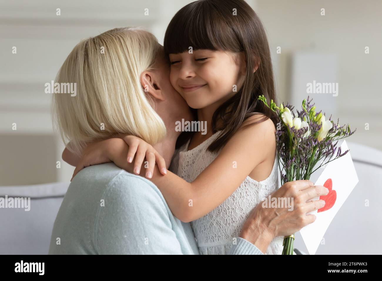 Cute little granddaughter hugging grandmother, congratulating with ...