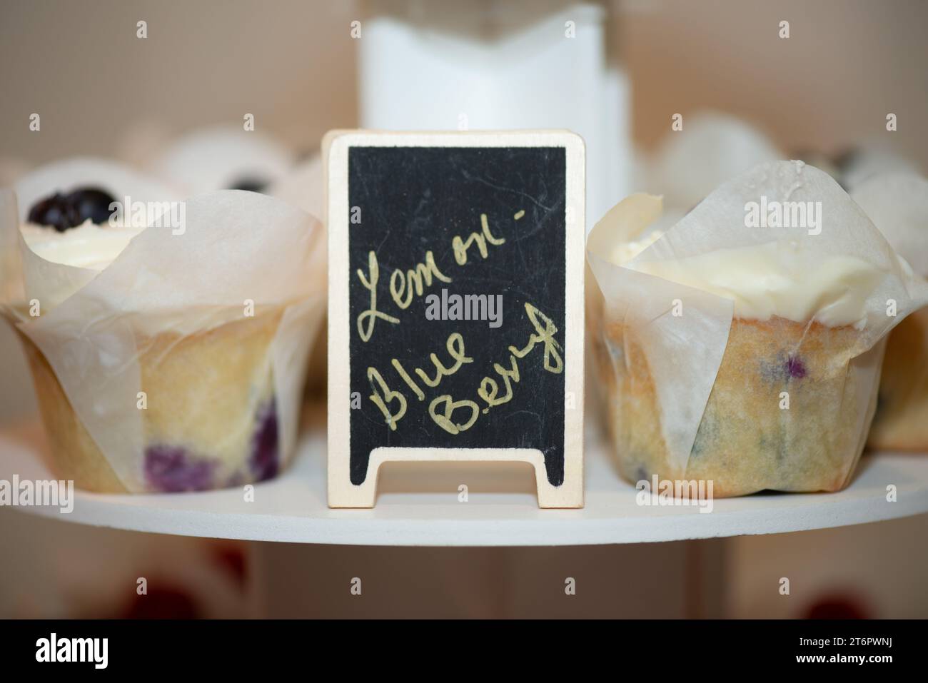 Lemon blueberry cupcakes on cake stand with chalkboard sign that reads ...