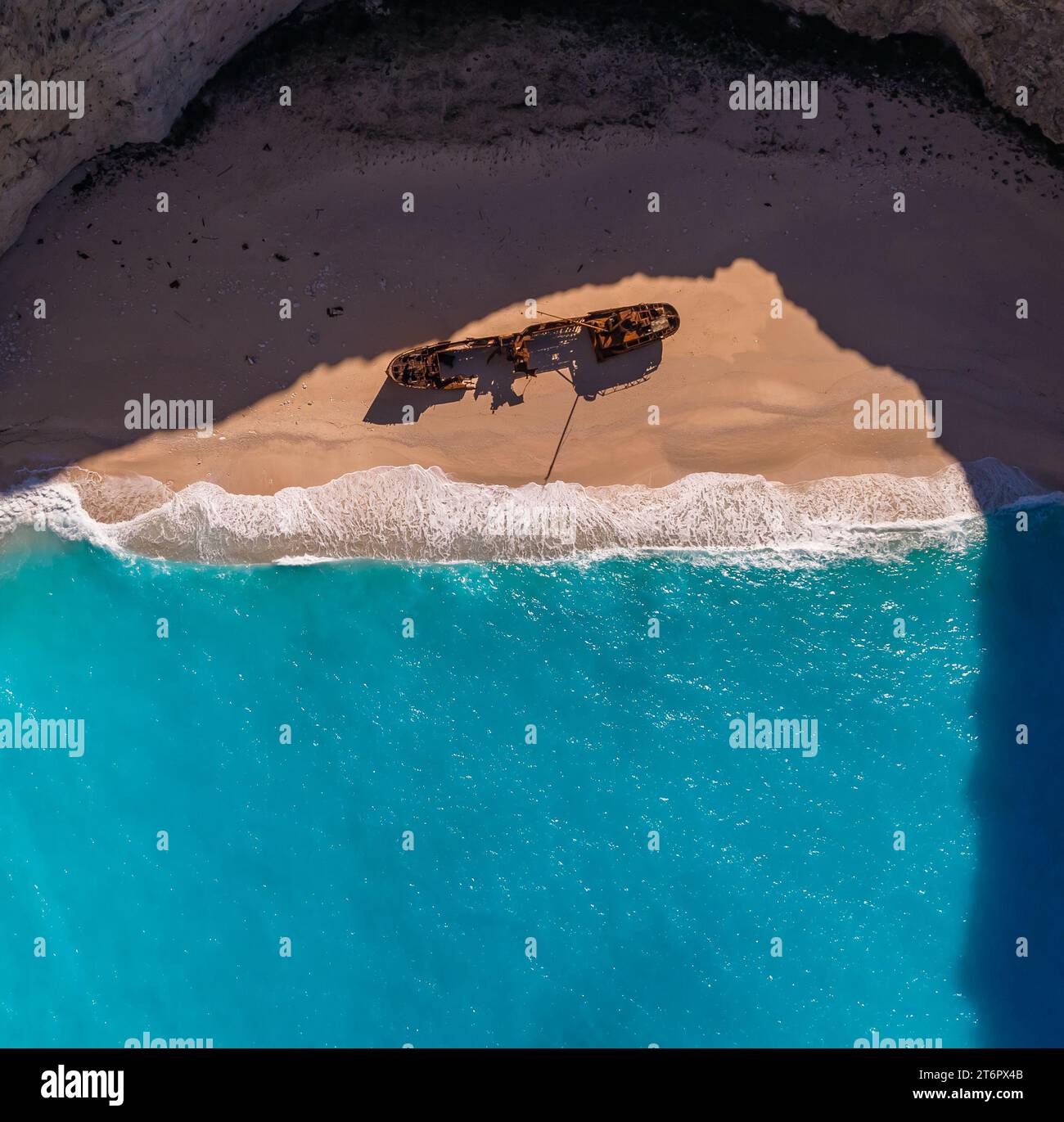 Aerial view of a boat securely moored to the white sandy shoreline of a ...