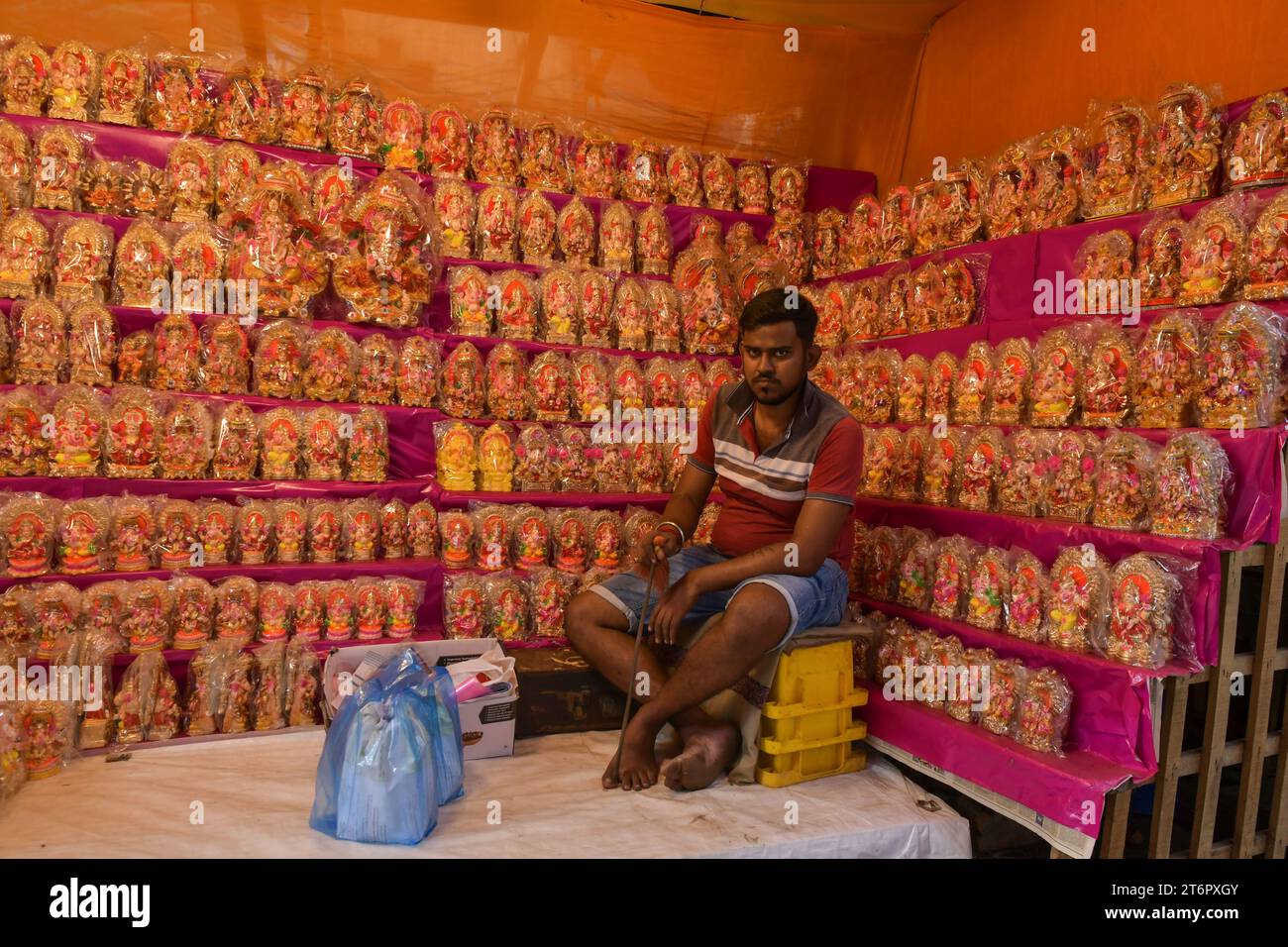 A shopkeeper seen selling idols of Lakshmi and Ganesh on the occasion ...