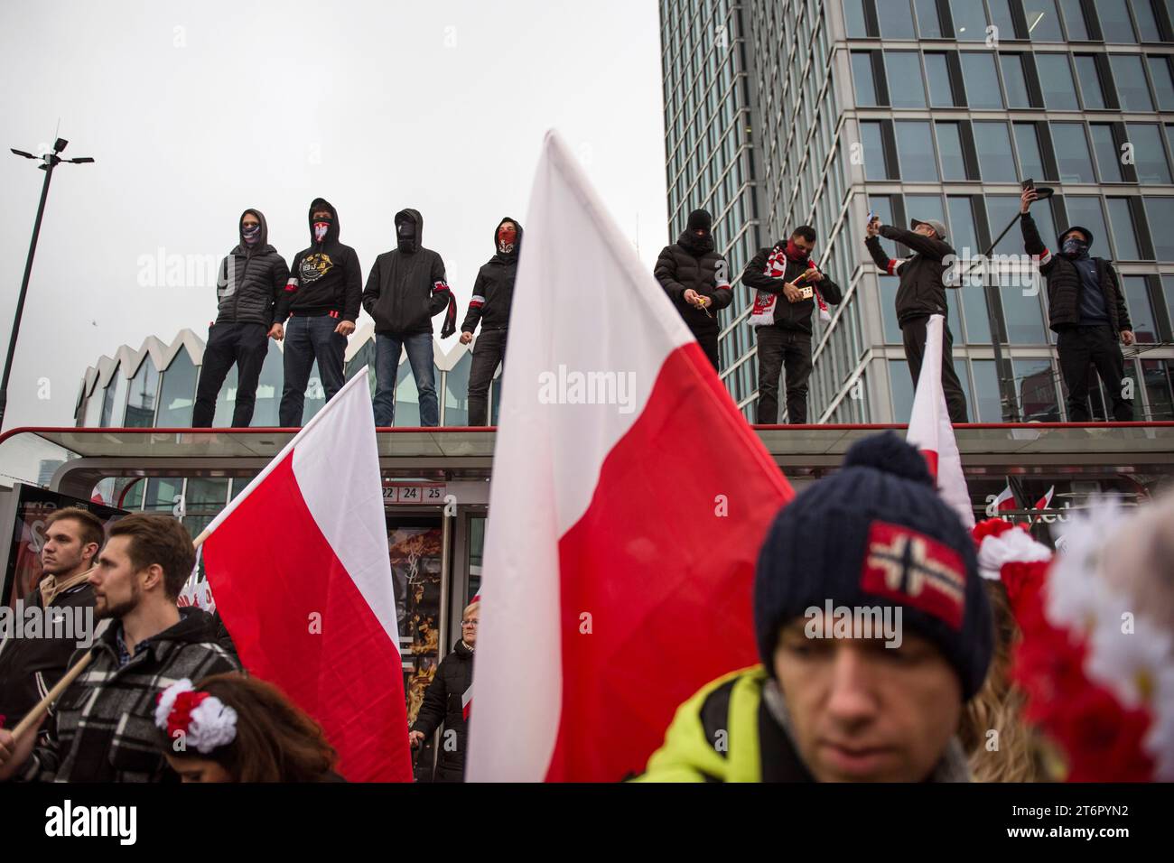 Masked football fans are seen occupying the roof of a bus stop during ...