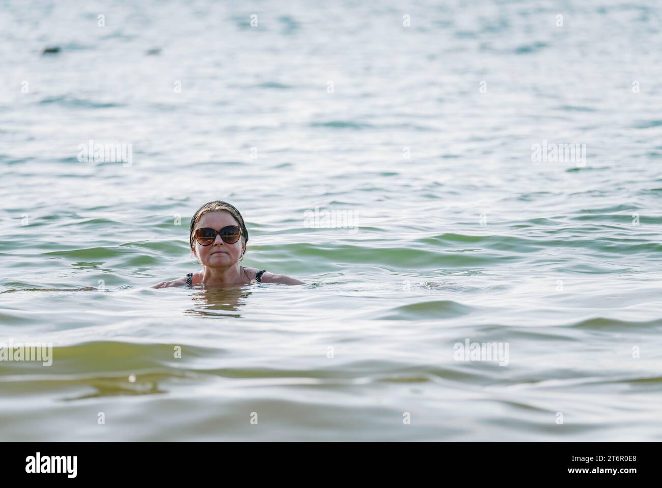 Attractive middle aged Scandinavian women in big sun glasses swimming ...