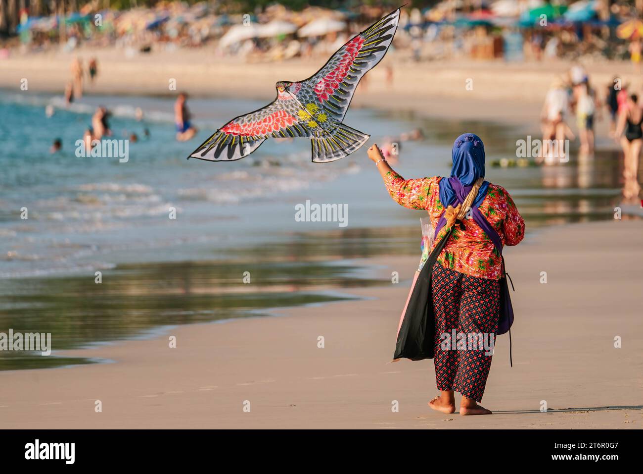 Thai women selling flying kite toy in form and color of predator bird ...
