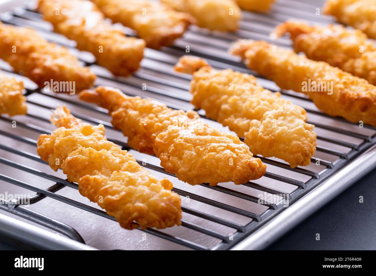 Cooked tempura shrimp on a cooling rack freshly made and ready to eat ...