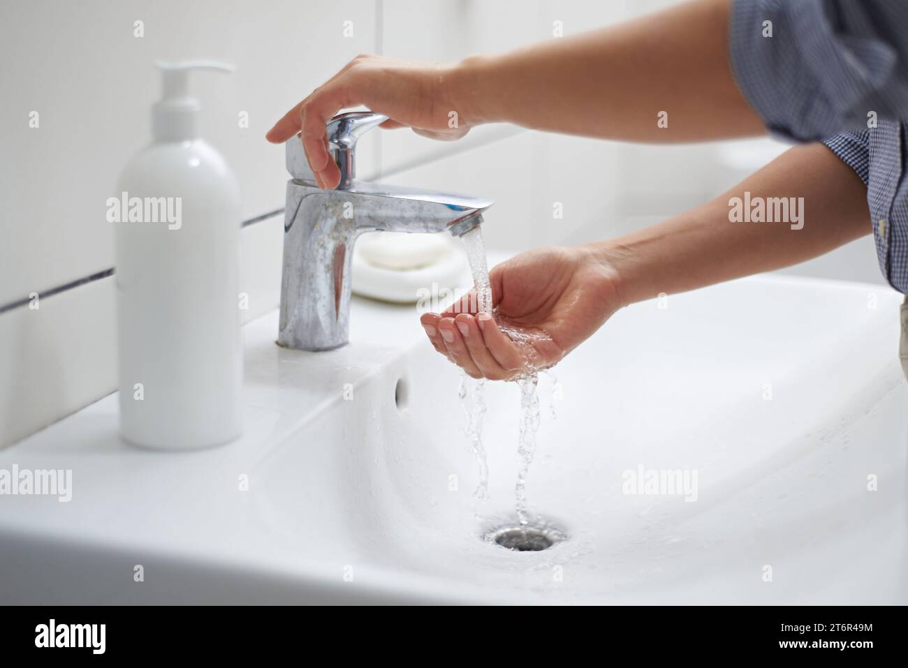 Close-up woman washing hands under running water, using an antiseptic ...