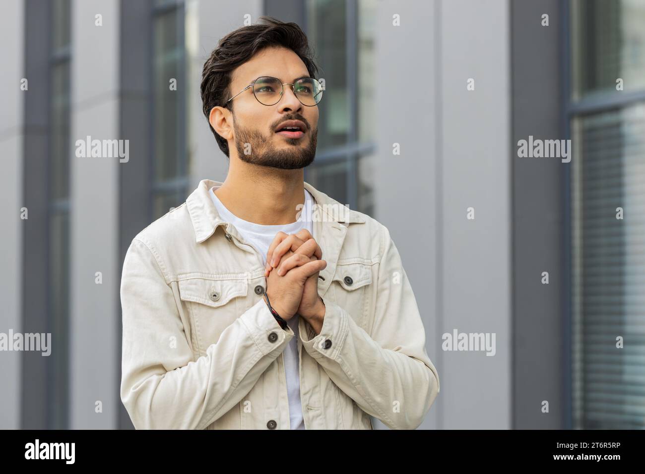 Young Indian man praying with closed eyes to God asking for blessing ...