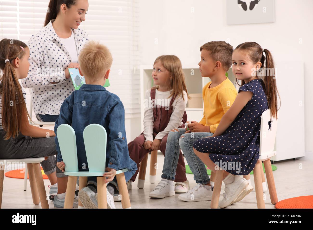 Nursery teacher and group of cute little children learning animals in ...