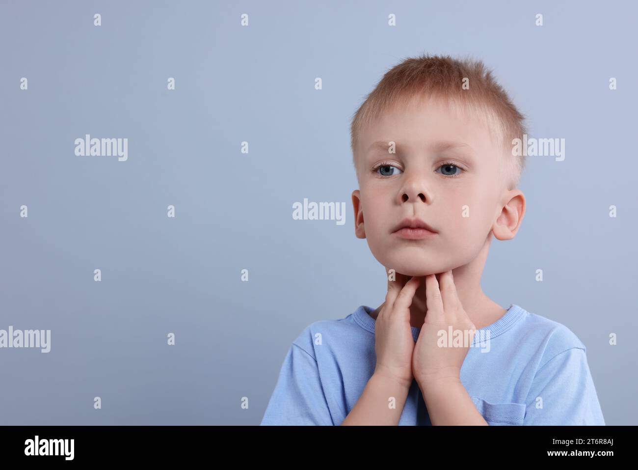 Endocrine system. Little boy doing thyroid self examination on light ...