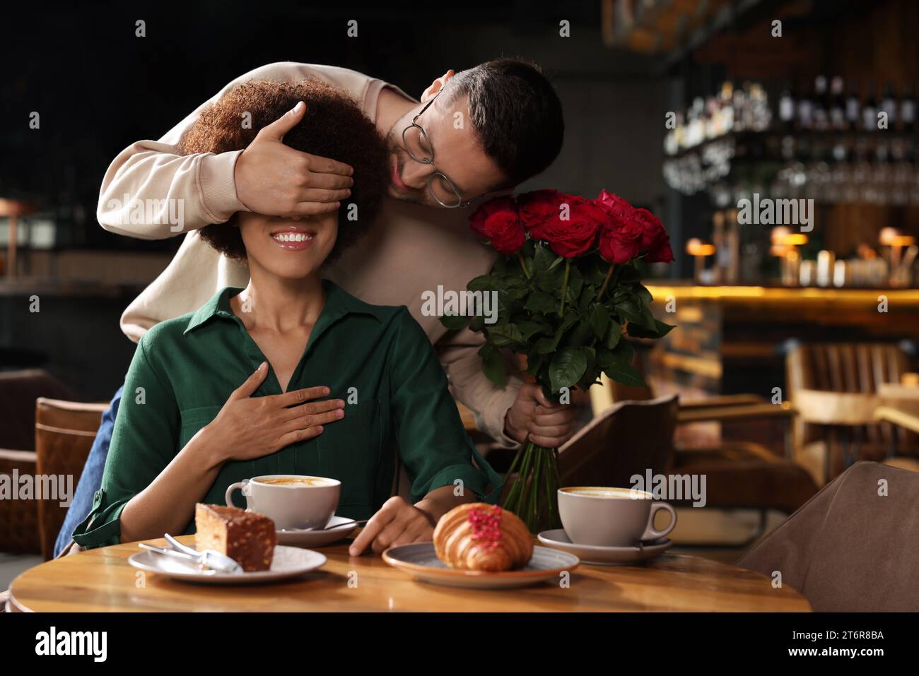 International dating. Handsome man presenting roses to his girlfriend ...