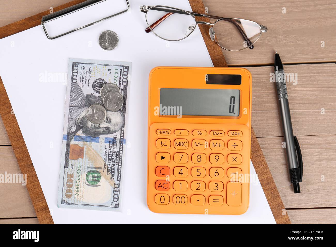 Orange calculator, money, clipboard with paper sheet, pen and glasses ...