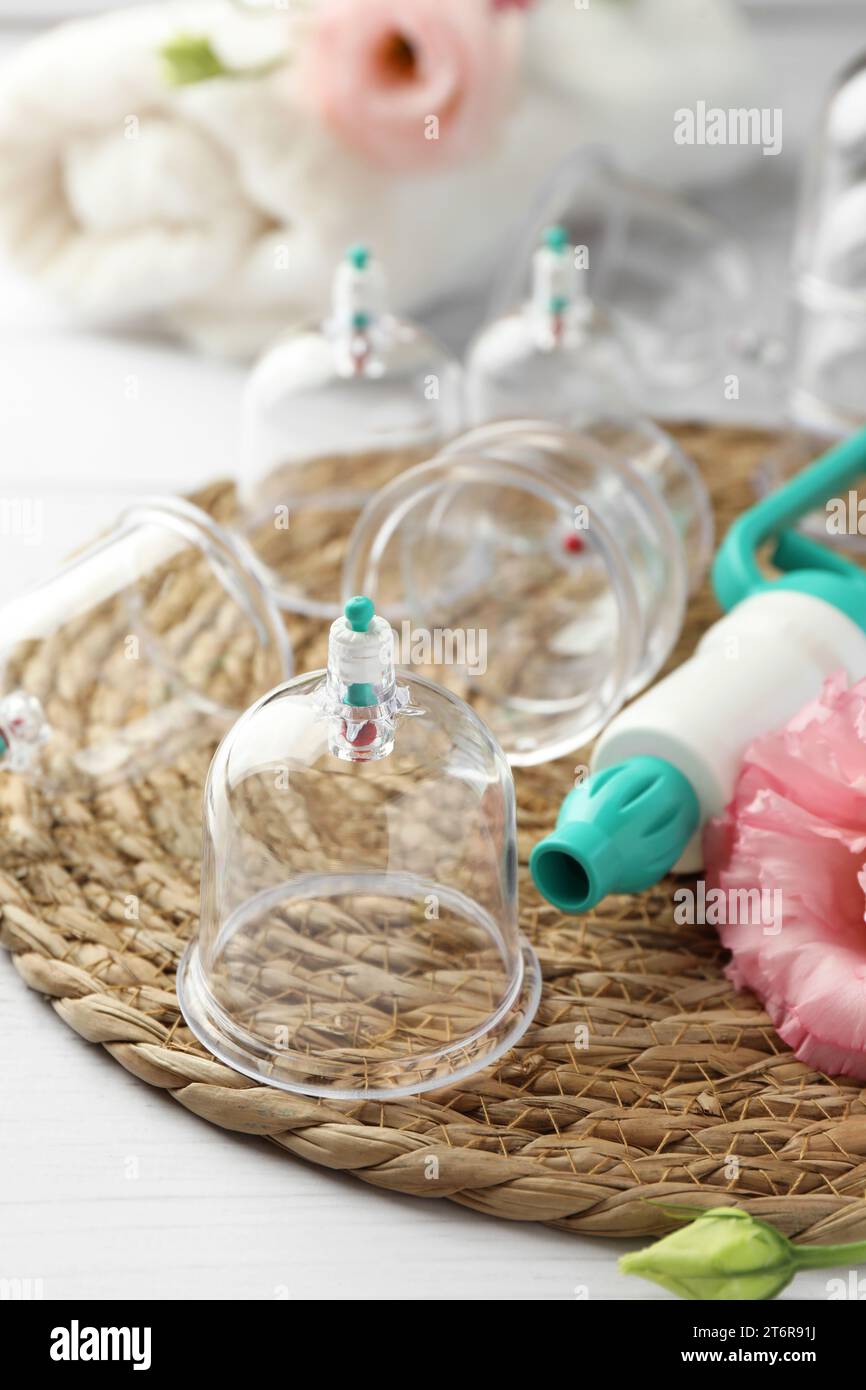 Plastic cups and hand pump on white table. Cupping therapy Stock Photo ...