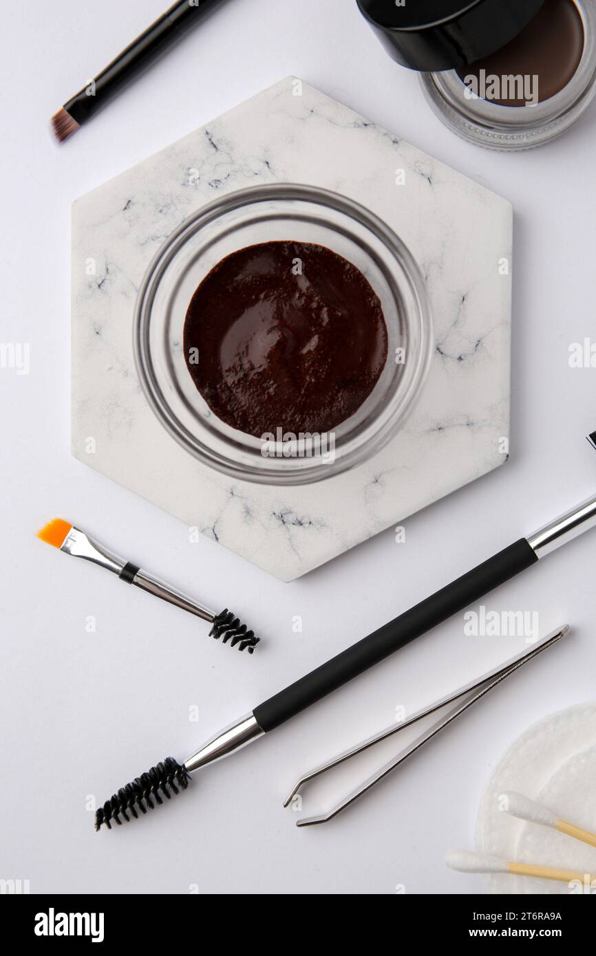 Flat lay composition with eyebrow henna and professional tools on white ...
