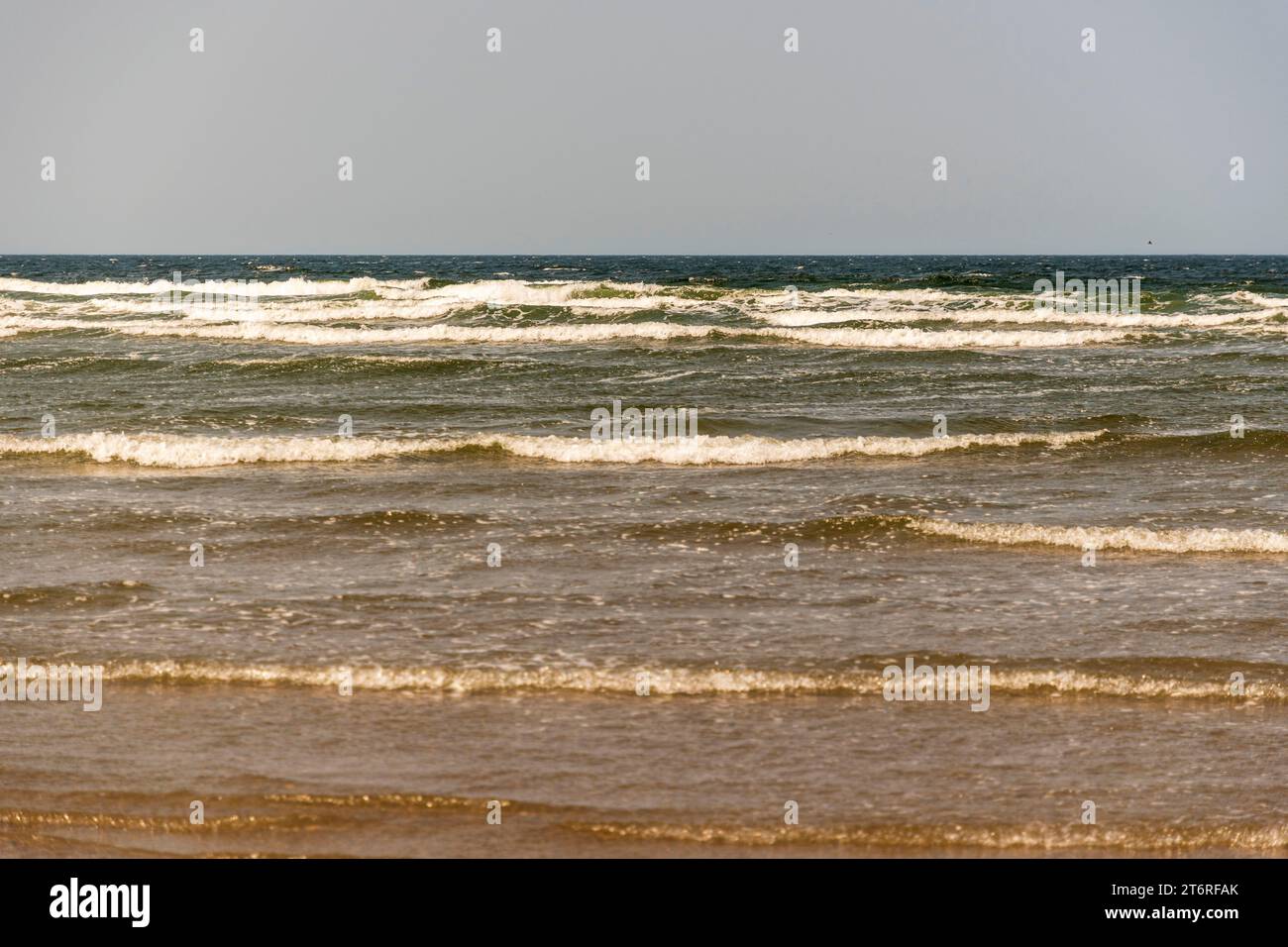 Horizontal image of gentle waves of the Pacific Ocean under a clear ...