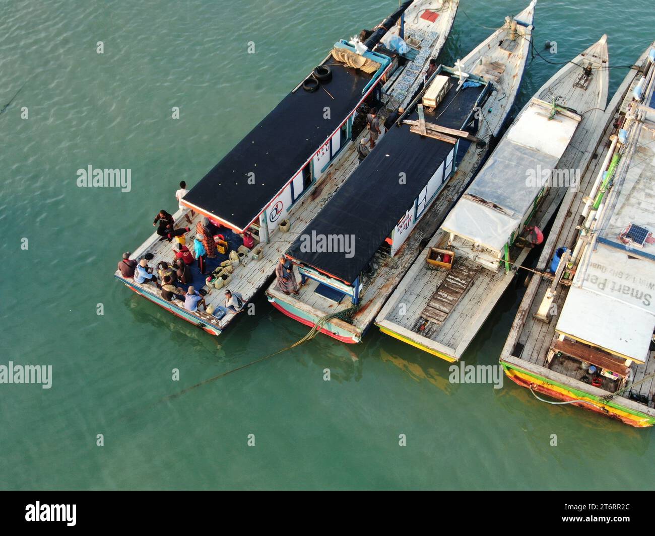 Fishing boats moored in the shallow waters Sumur beach of Banten ...