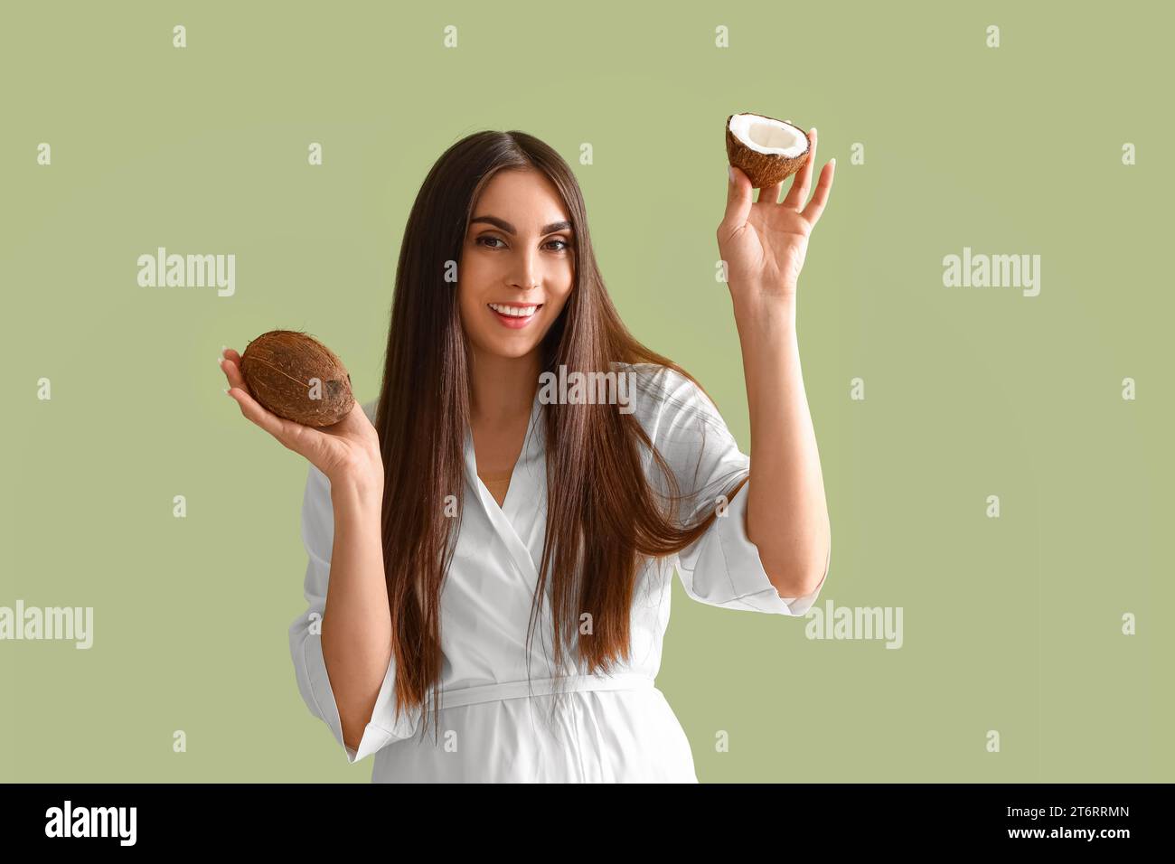 Beautiful young woman with coconut on green background Stock Photo - Alamy