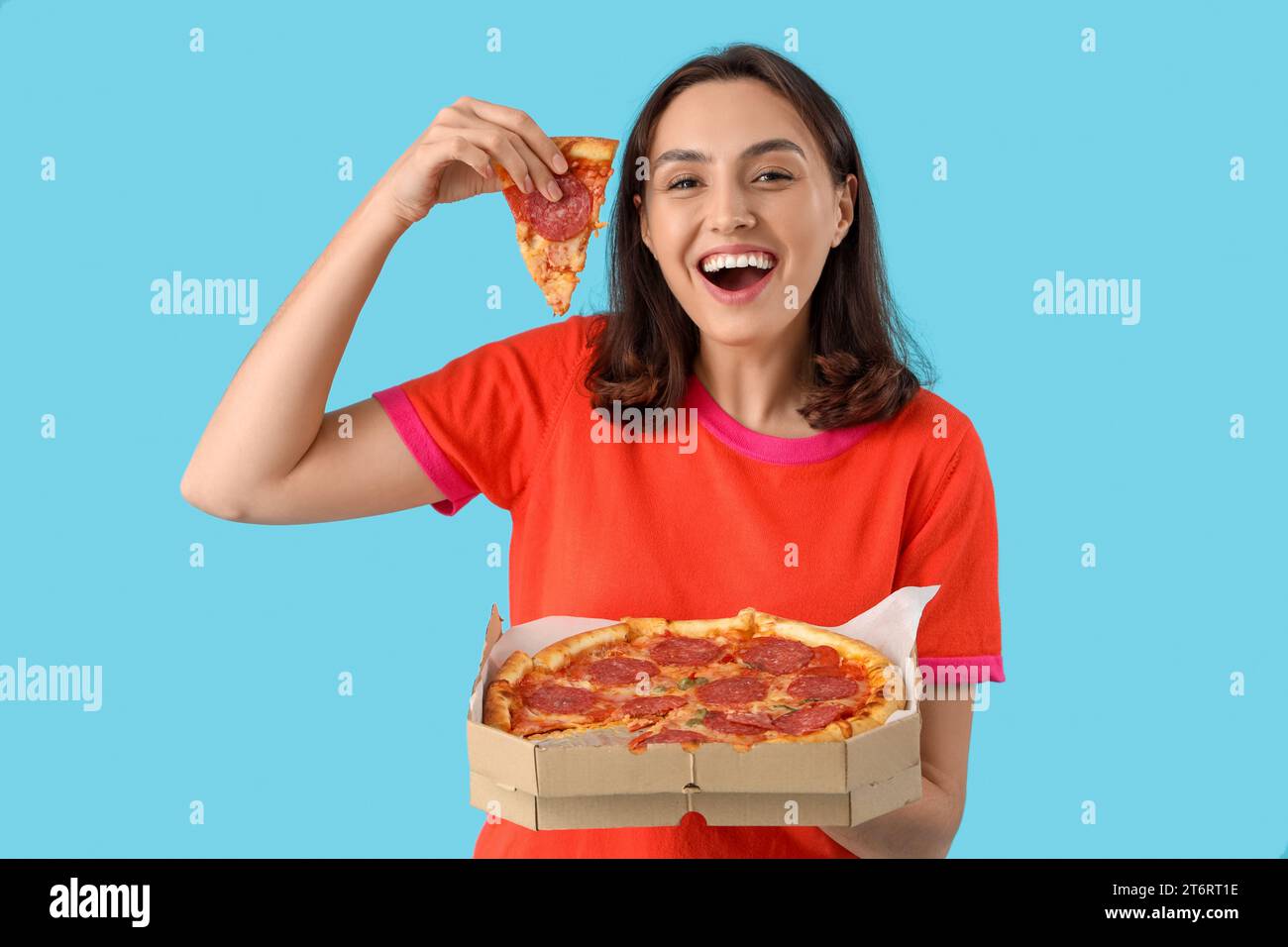 Young woman with tasty pepperoni pizza on blue background Stock Photo ...