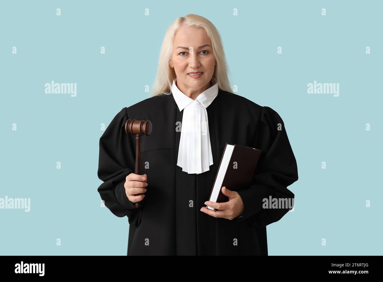 Mature female judge with book and gavel on blue background Stock Photo ...