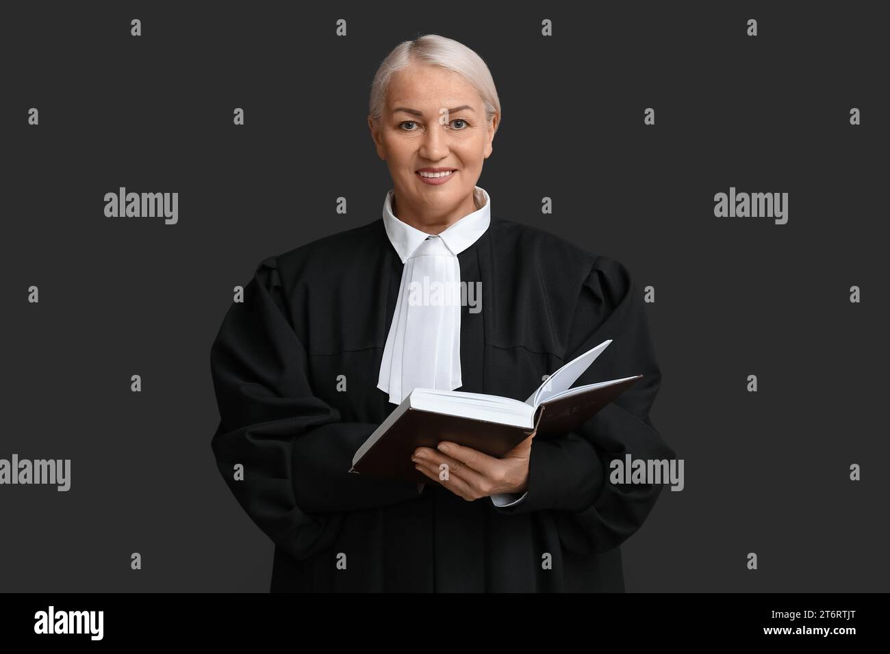Mature female judge with book on black background Stock Photo - Alamy