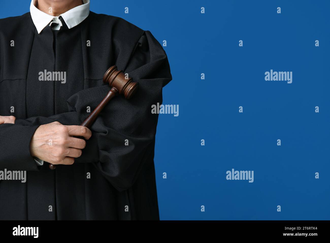 Female judge with crossed arms and gavel on blue background Stock Photo ...