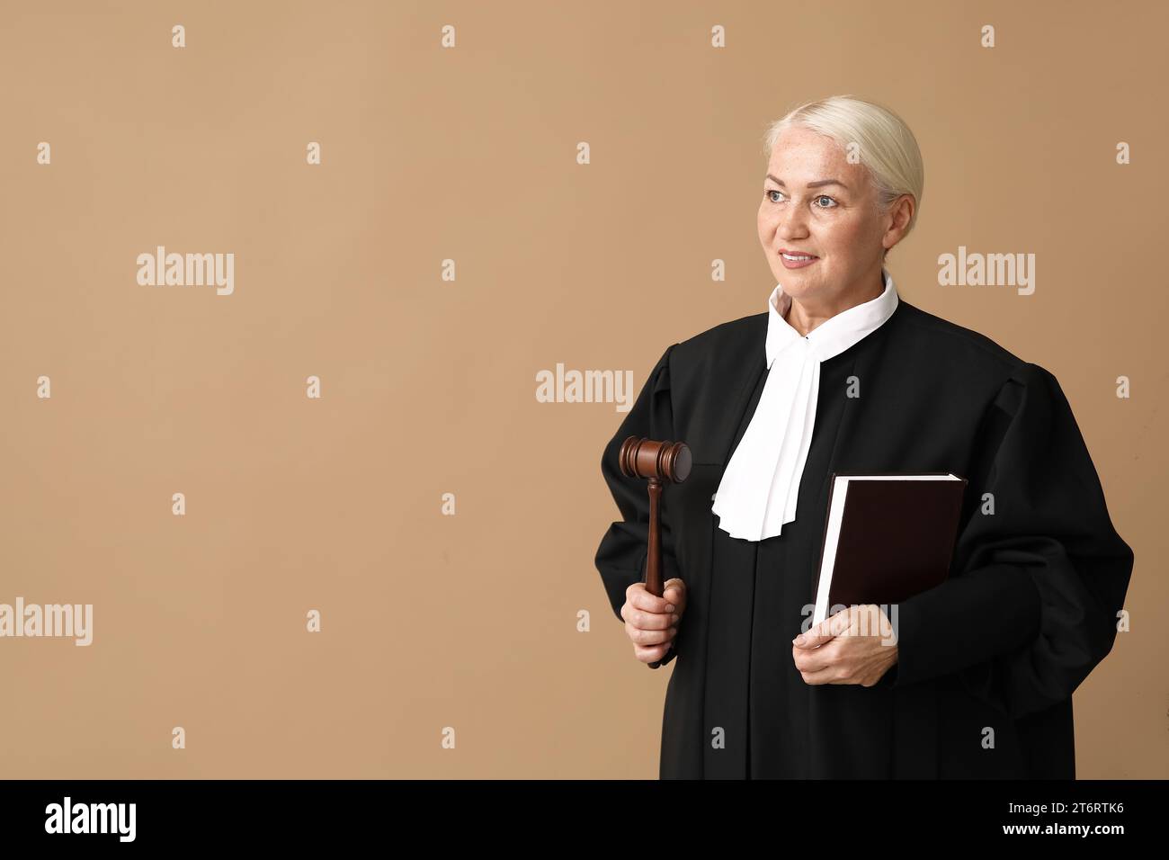 Mature female judge with book and gavel on brown background Stock Photo ...