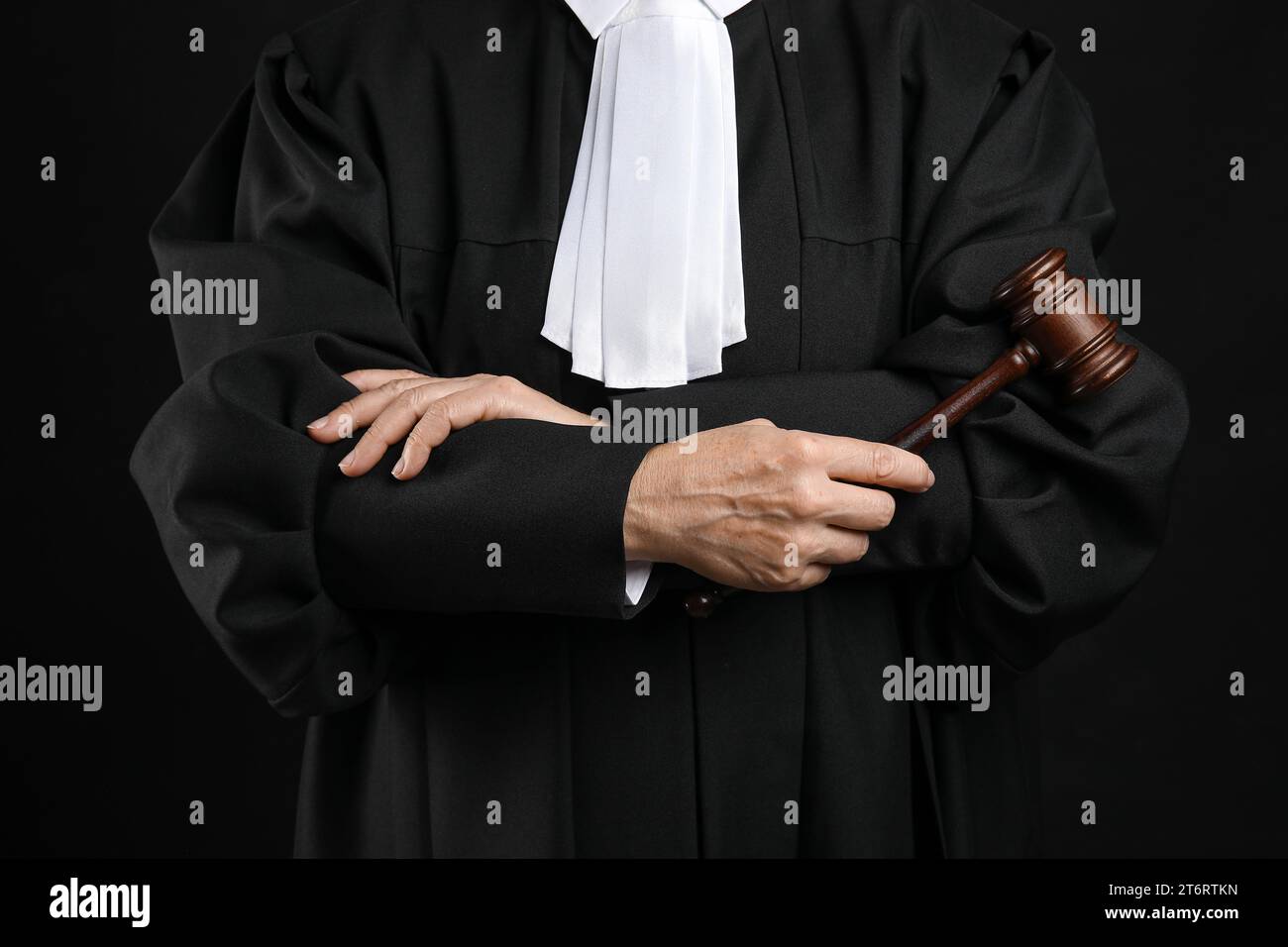 Female judge with crossed arms and gavel on black background Stock ...