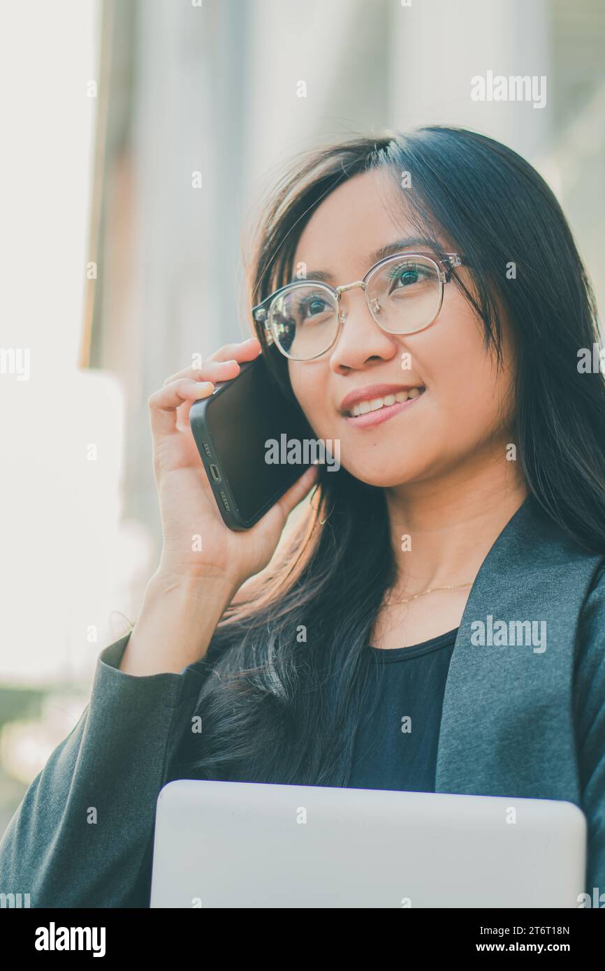 Confident businesswoman using mobile smart phone and working online ...