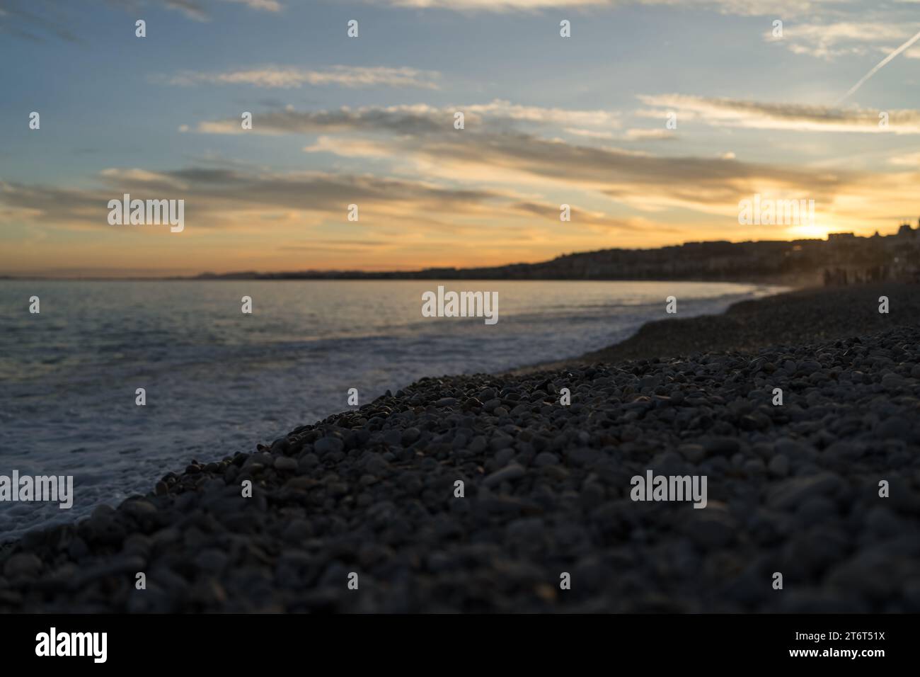 Sunset on the French Riviera pebble beach in Nice with blurred people ...
