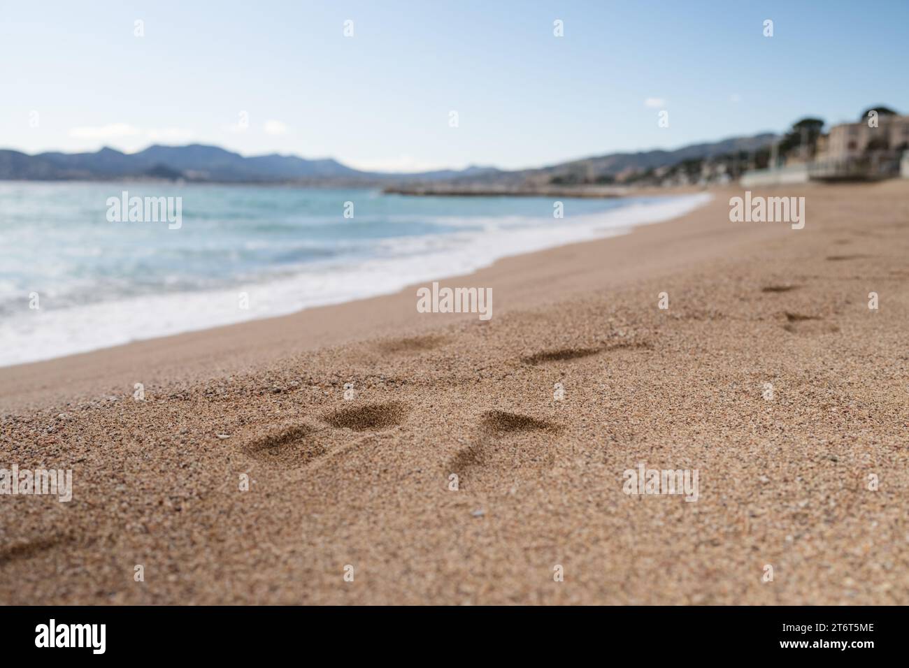 Footsteps on a sand beach of South France during spring with sea waves ...
