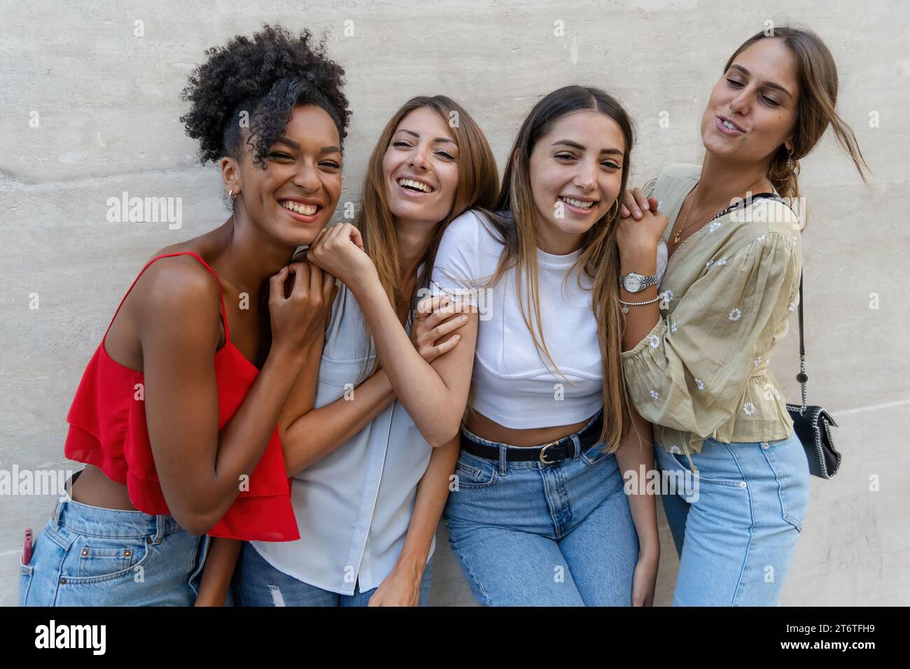 Four female friends laugh in a city setting, embodying authenticity and ...