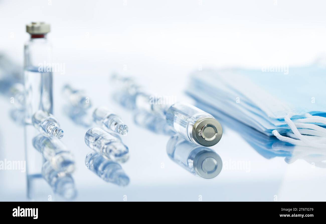Medical ampoules for injection and disposable masks over desk ...