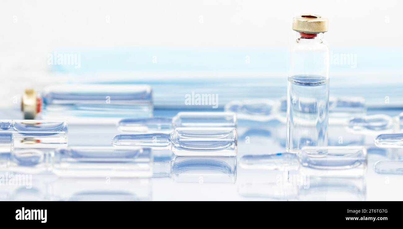 Medical ampoules for injection on a light blue background. Scattered ...