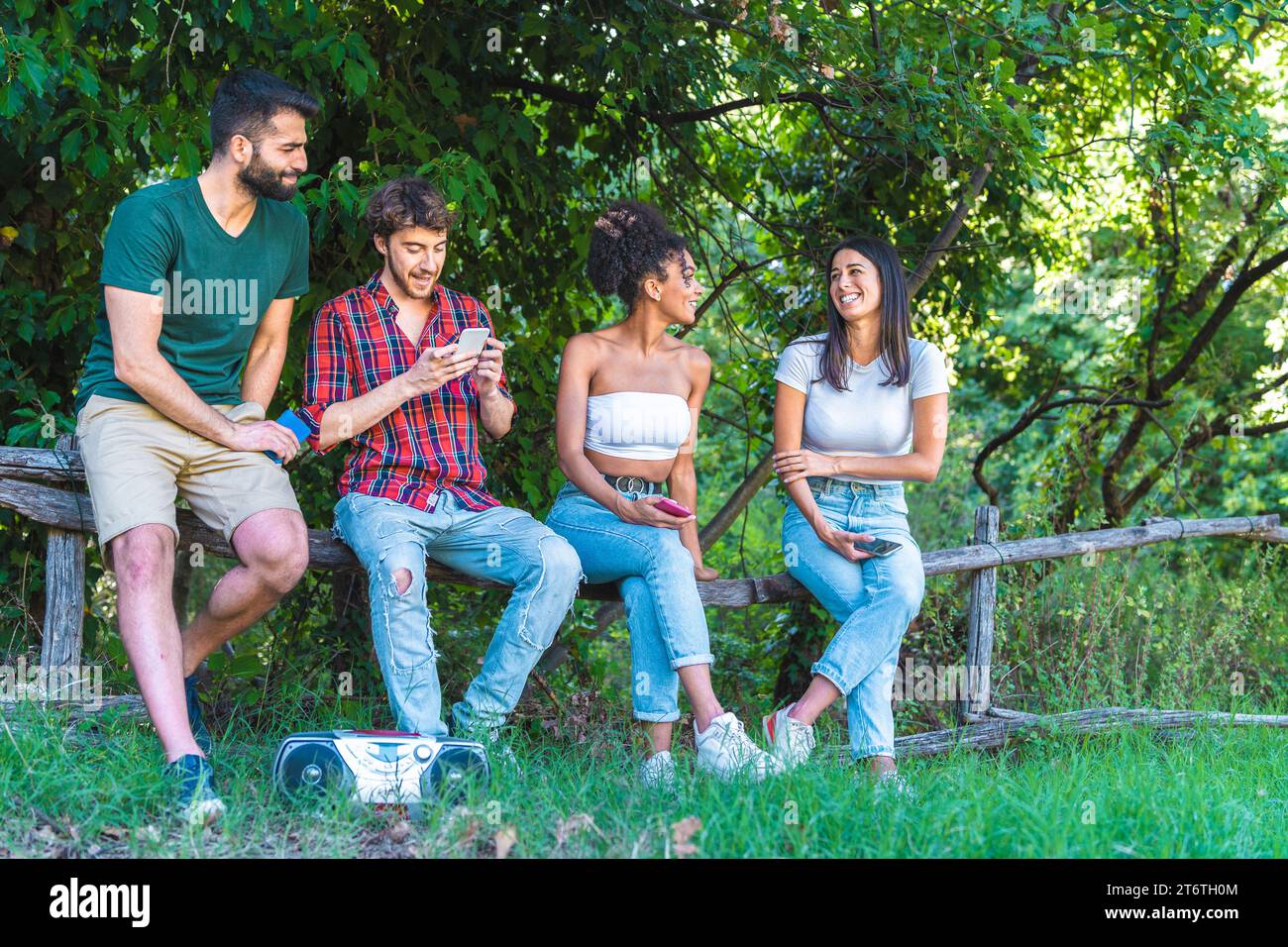 Group of diverse friends using smartphones and laughing together in a ...