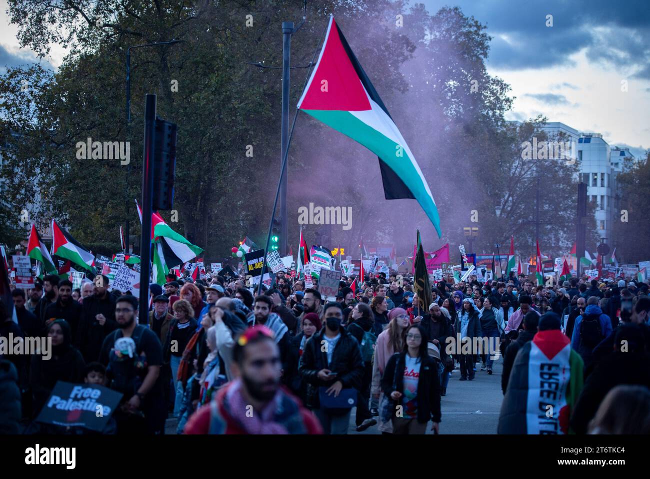 A crowd of protestors march with large Palestinian flags during the ...