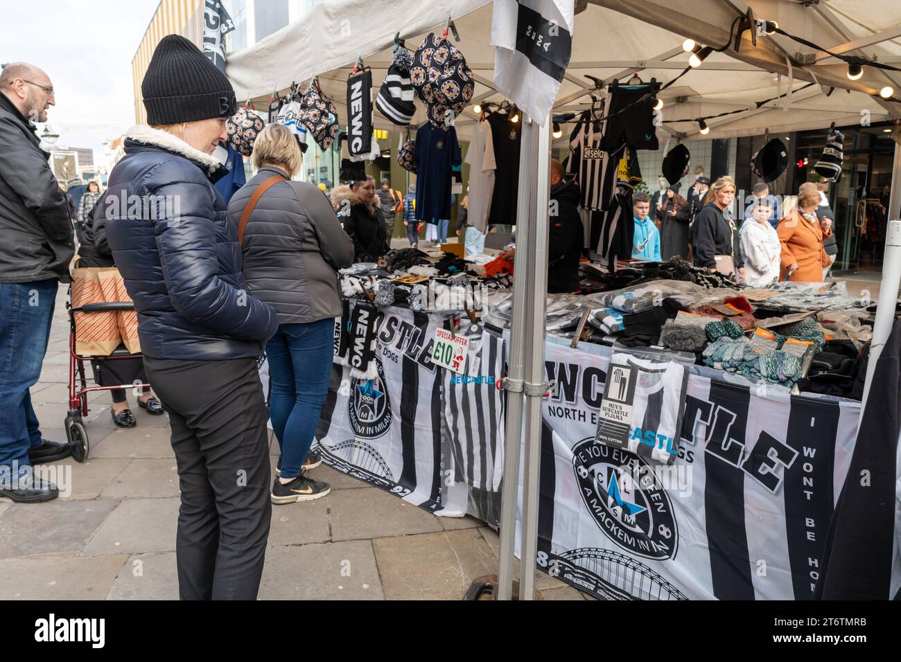 People shopping at a market stall selling football team themed items in ...