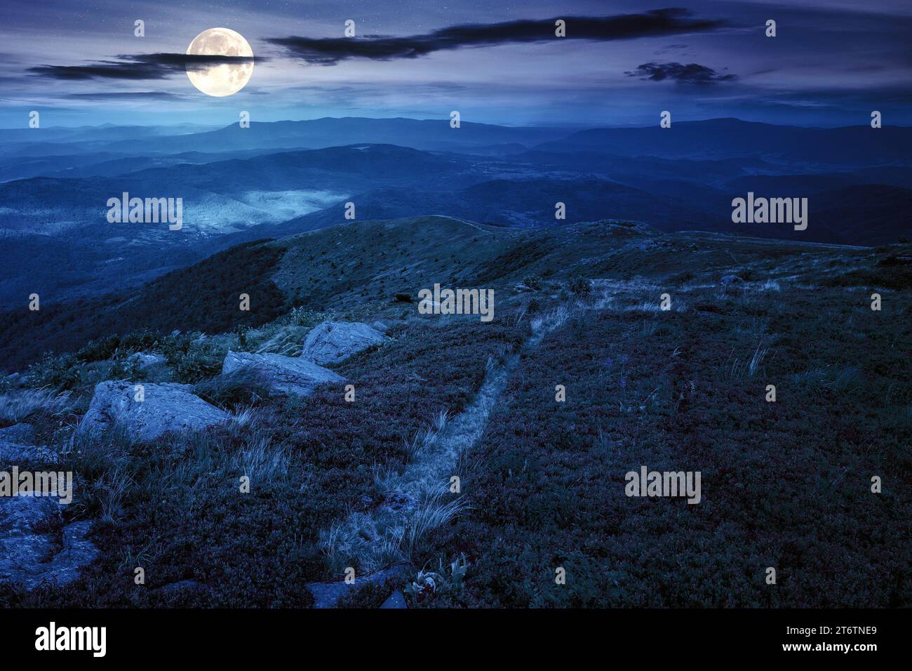 mountain landscape at night. stones in grass on the edge of hill ...