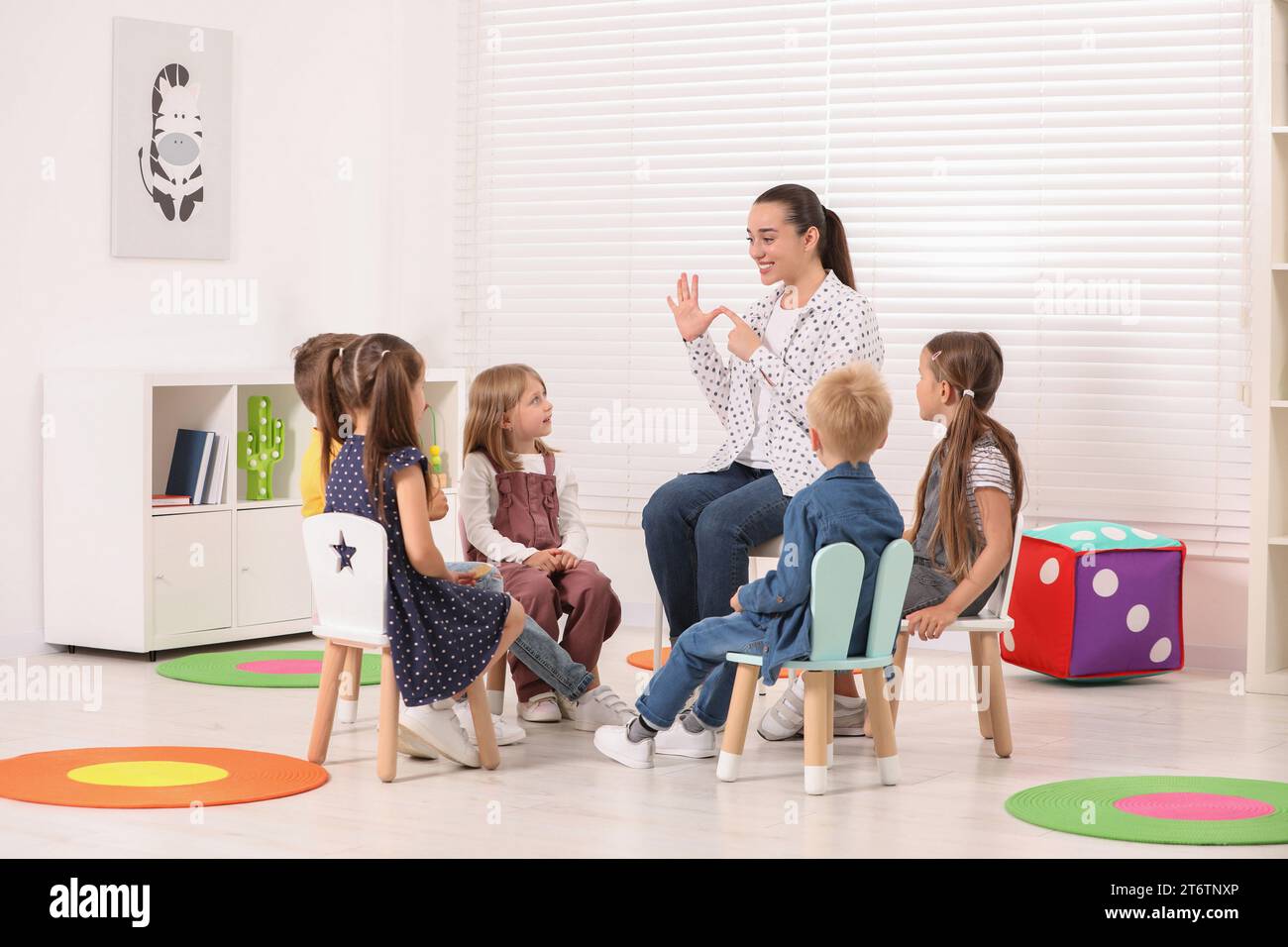 Nursery teacher and group of cute little children learning numbers in ...