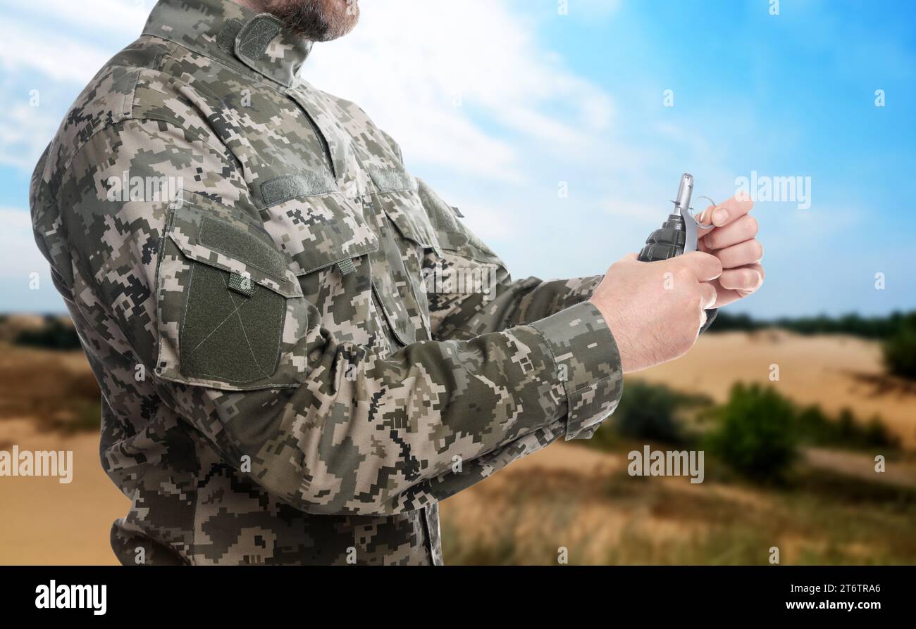 Soldier pulling safety pin out of hand grenade outdoors, closeup Stock ...