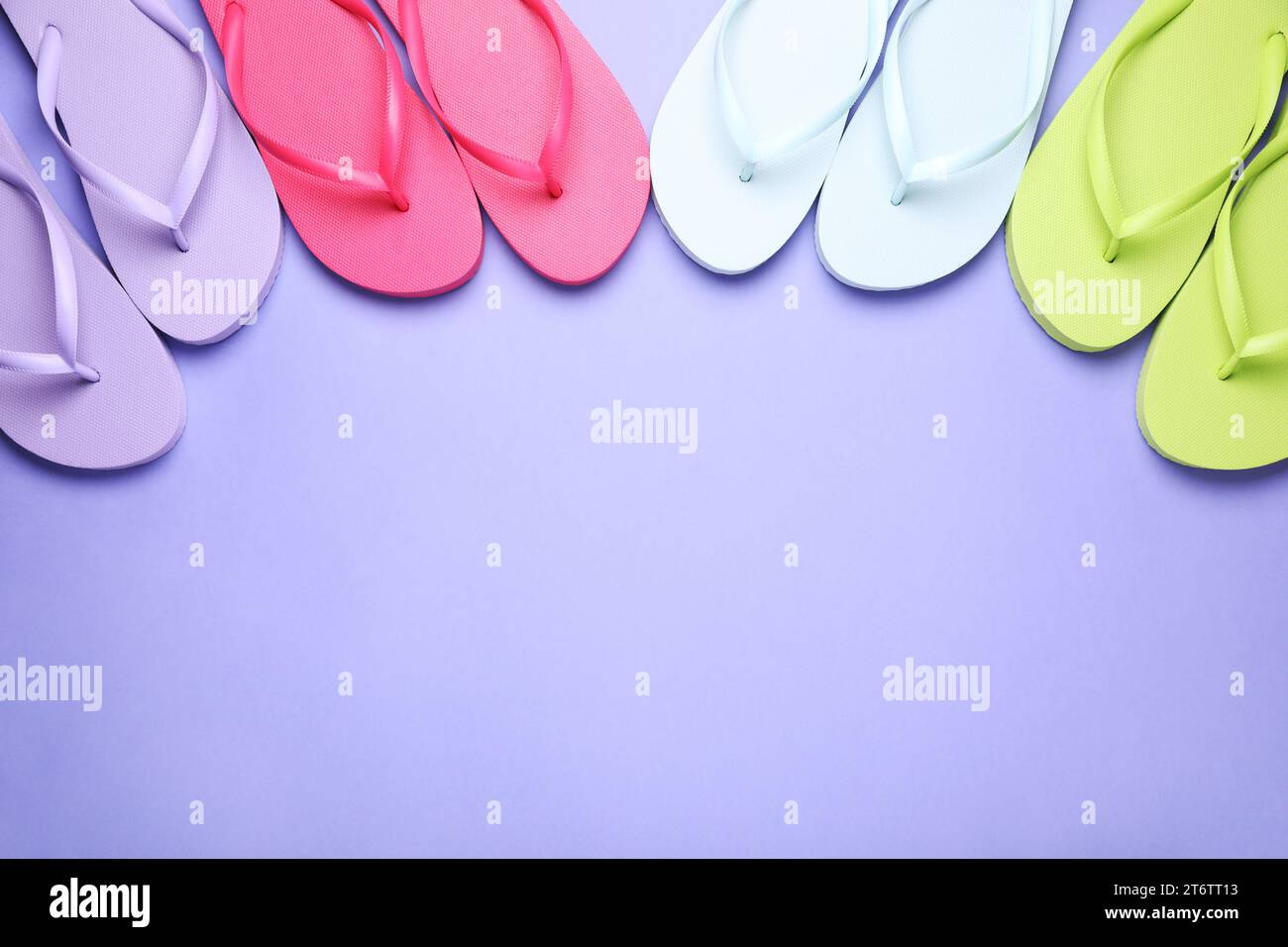 Many different flip flops on light purple background, flat lay. Space ...